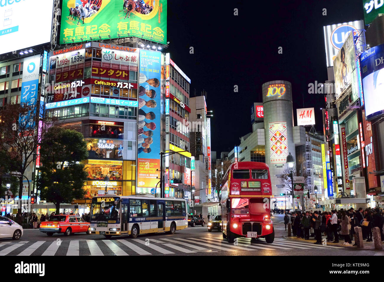 A London double-decker bus driving over the famous Shibuya crossing in ...