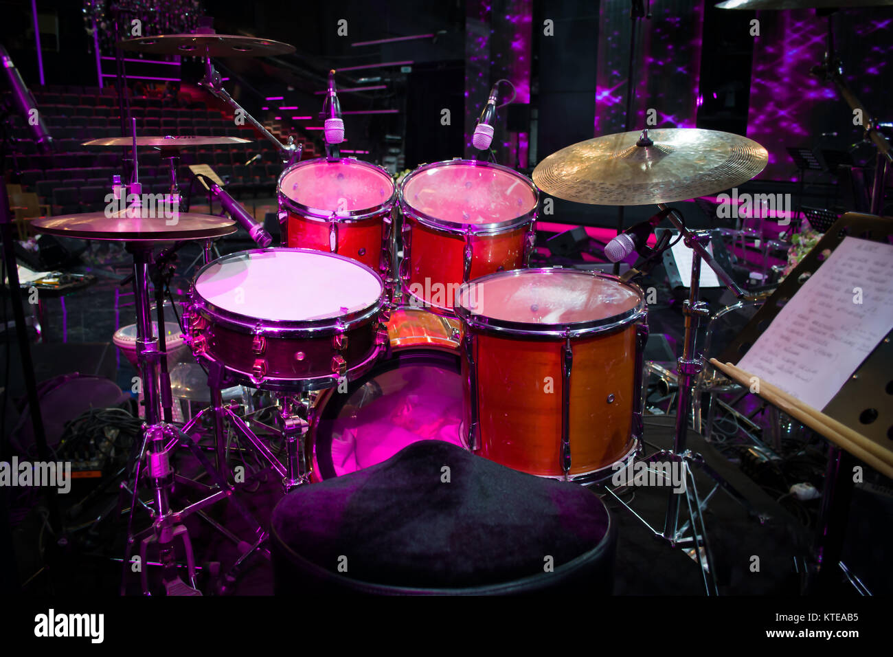 drum set with two wooden drumsticks and music notes in concert studio ...