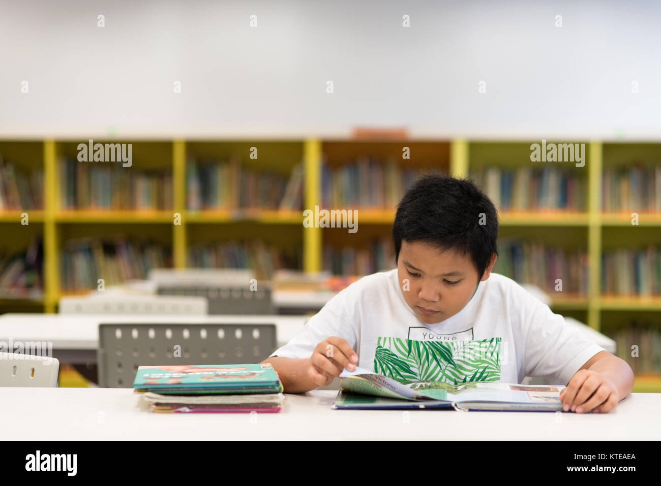 asian boy reading a book in a library. education concept Stock Photo ...