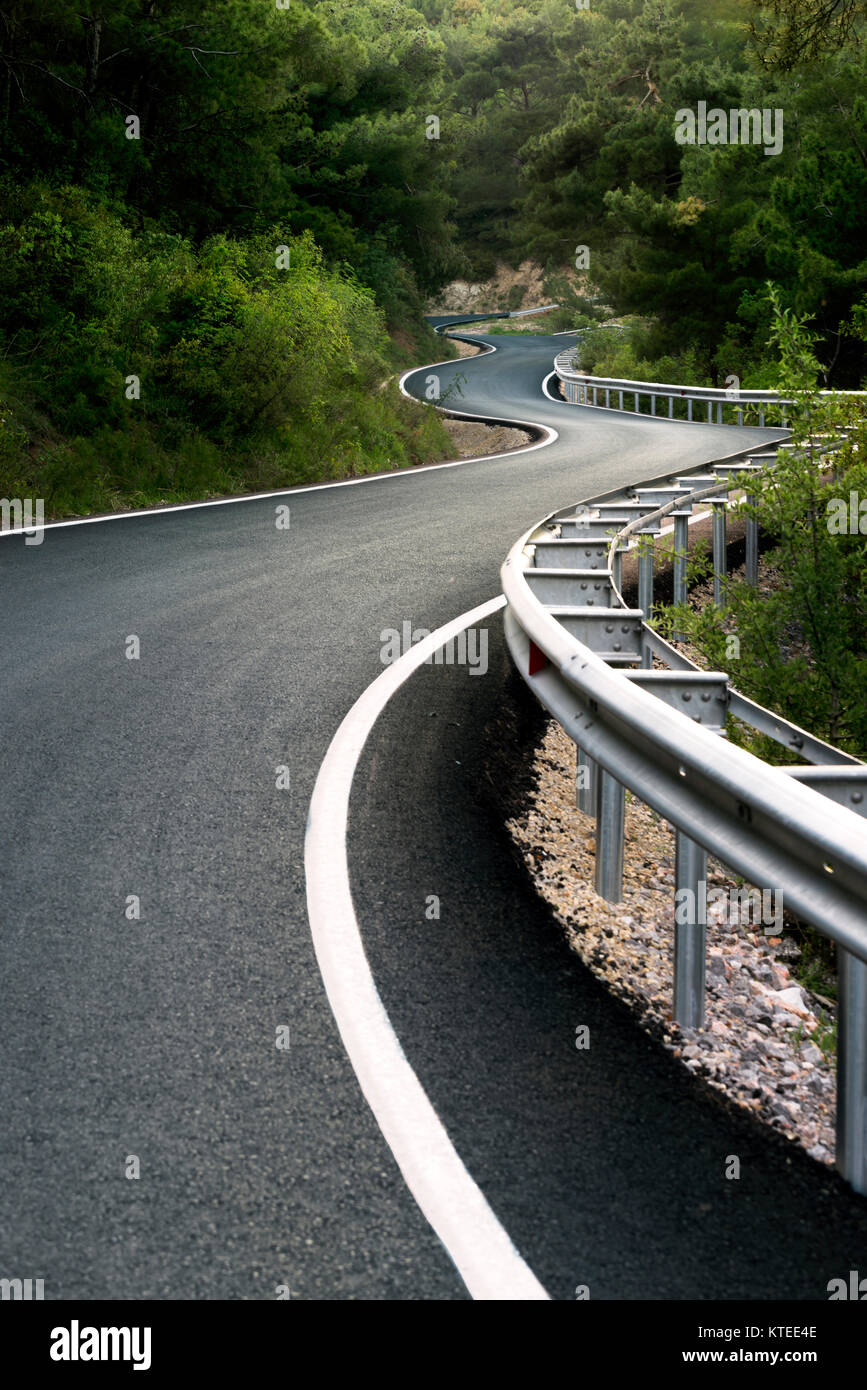 S shaped new road in the forest Stock Photo - Alamy
