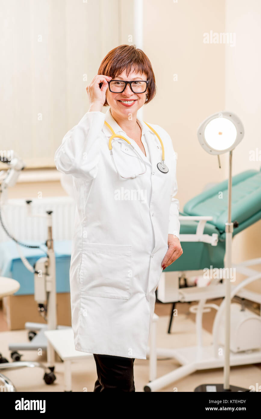 Portrait of a senior woman gynecologist standing in the office with ...