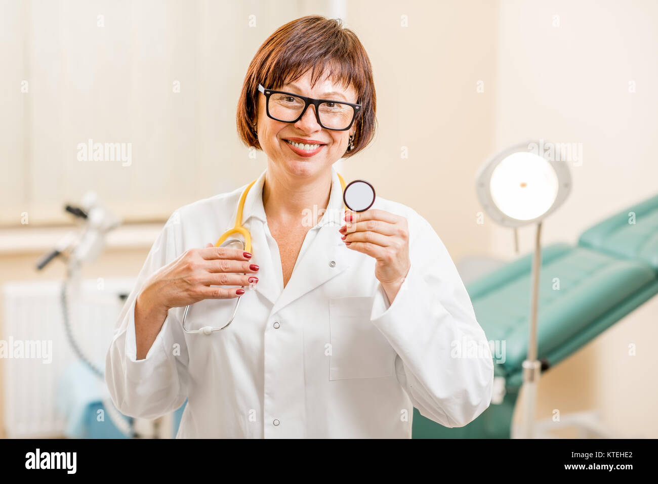 Portrait of a senior woman gynecologist standing in the office with ...