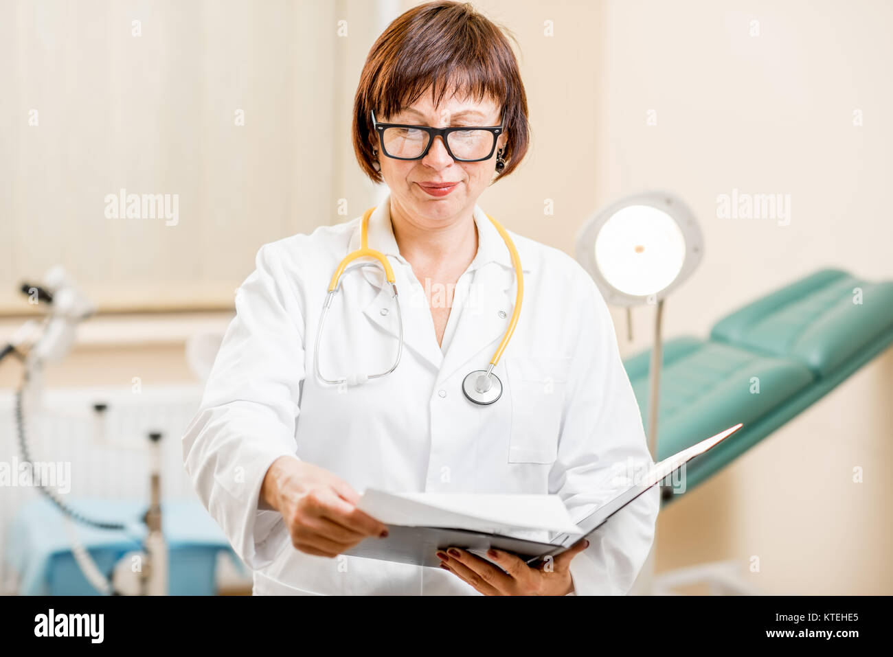 Portrait of a senior woman gynecologist standing in the office with ...