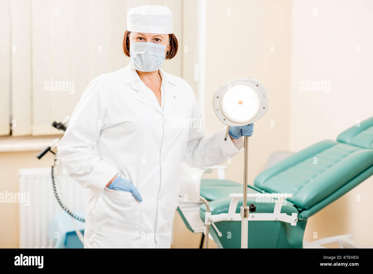 Portrait of a senior woman gynecologist in medical gown and hat ...