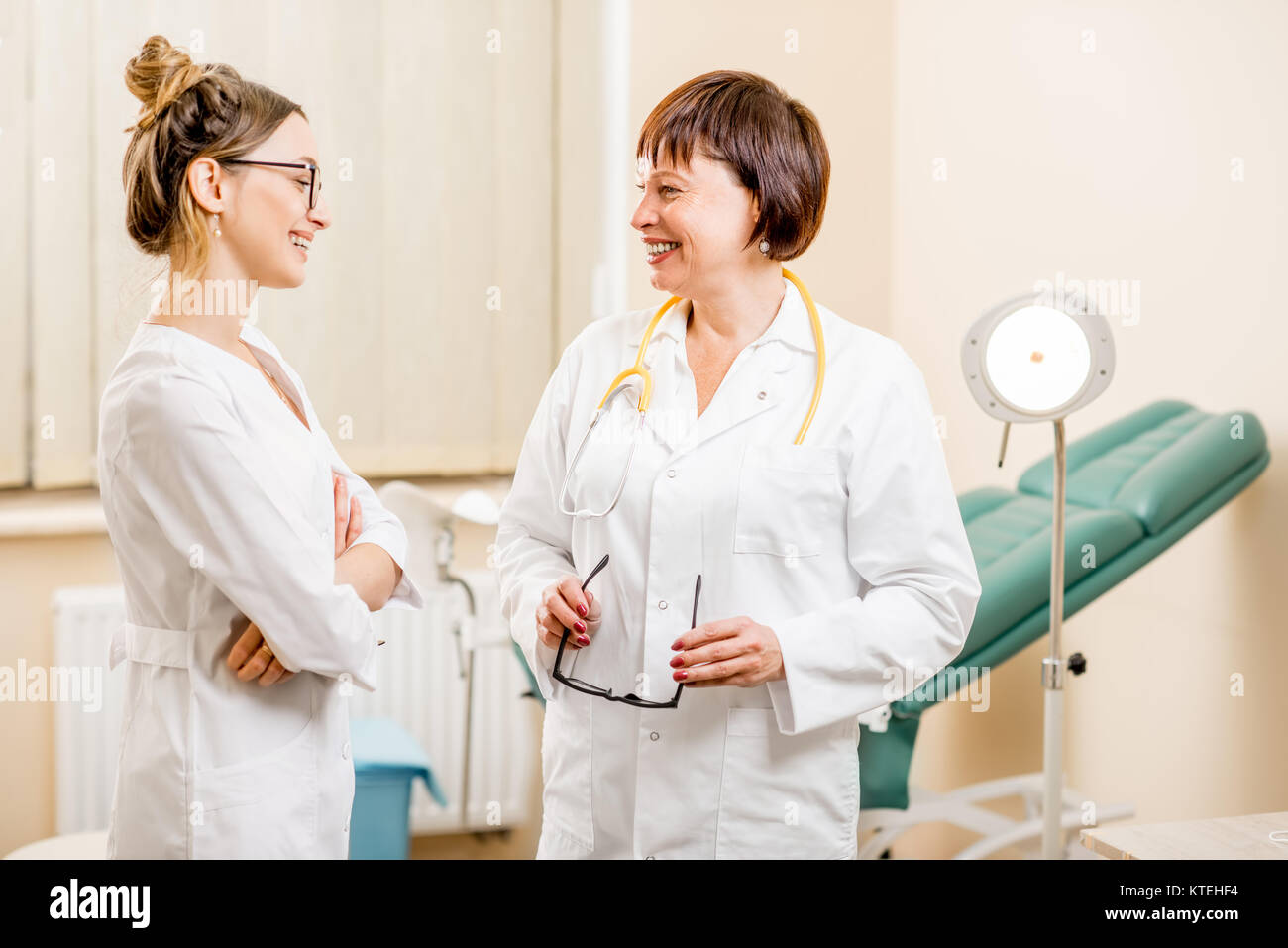 Senior doctor talking with young woman assistant standing in the ...