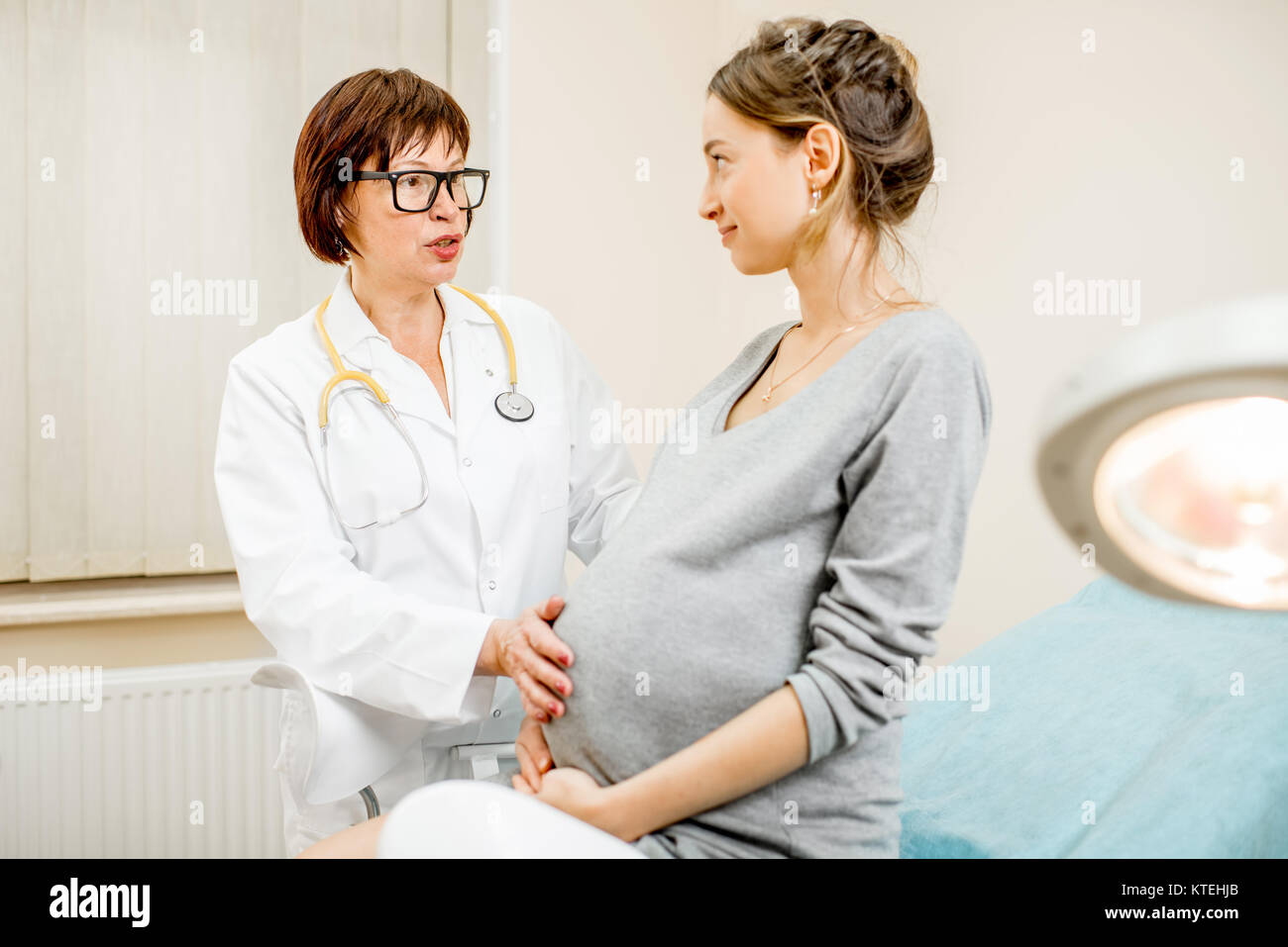 Pregnant woman patient with a senior gynecologist during the ...