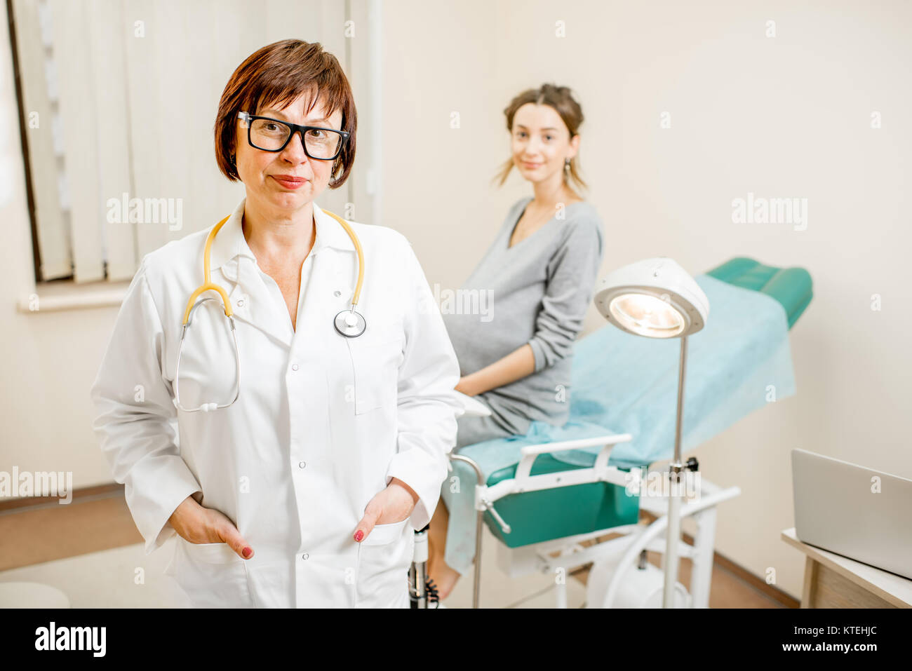 Portrait of a senior woman gynecologist standing in the office with ...