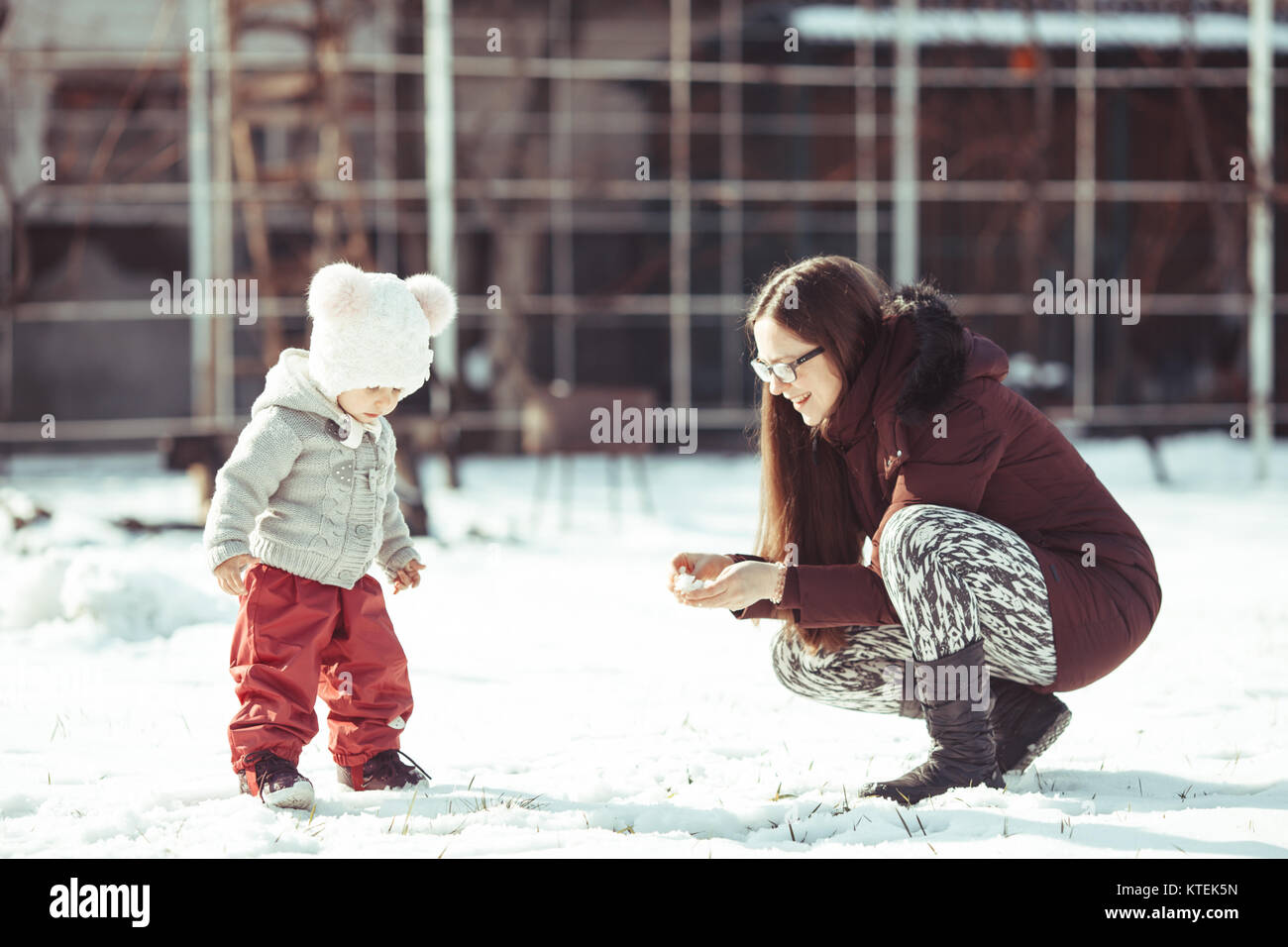 Mom shows the snow to a little girl at the cold sunny winter day Stock ...