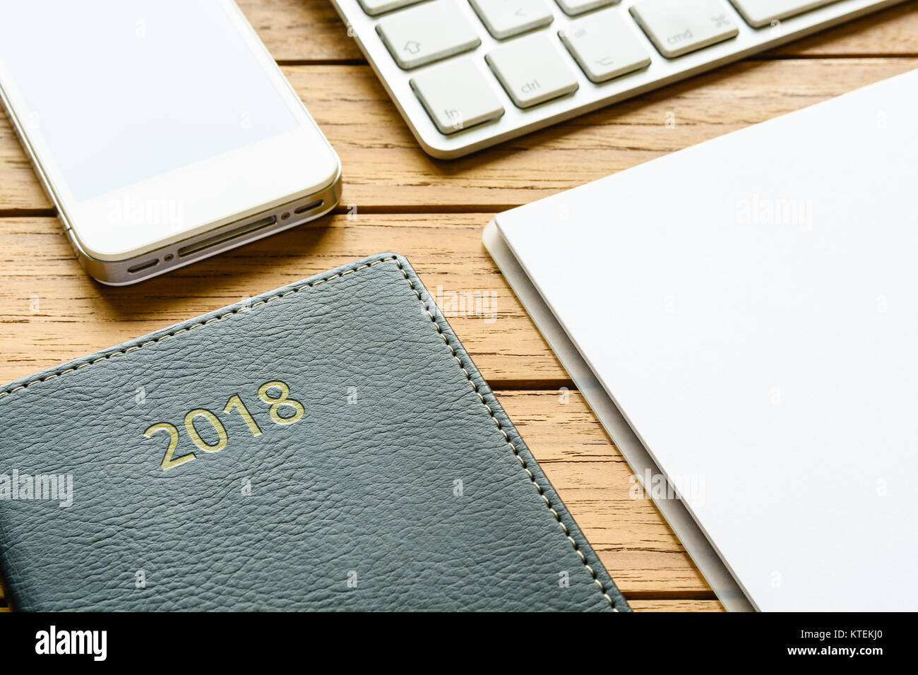 Neat wooden desktop with 2018 diary, smartphone, keyboard and notebook ...