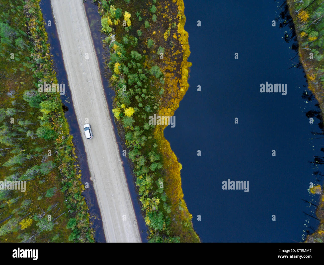 Top view at car driving on dirt road in swampland with lakes window ...