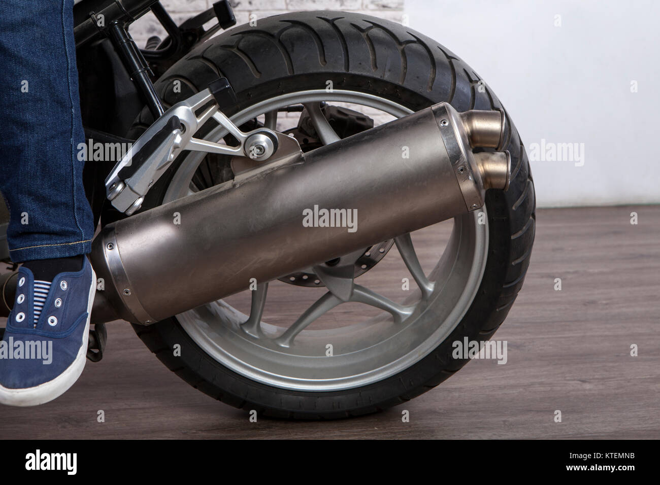 Rear motorcycle wheel with steel exhaust pipe Stock Photo - Alamy