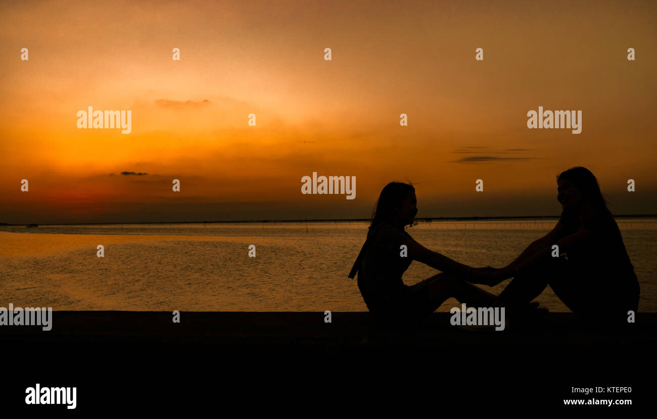 Two girls sunset silhouette hi-res stock photography and images - Alamy