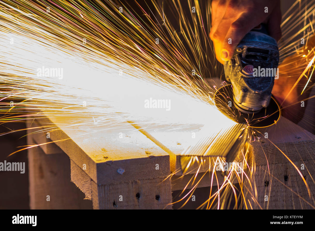 Close-up of worker hands cutting metal with grinder. Sparks while ...