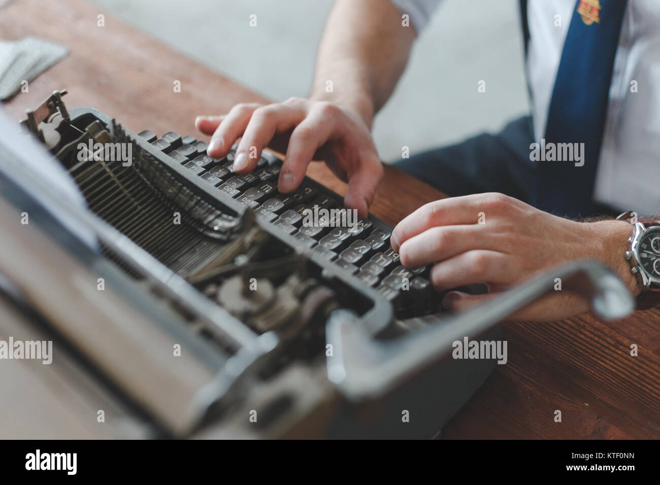 Man working on retro typewriter at desk in parlor room Stock Photo - Alamy