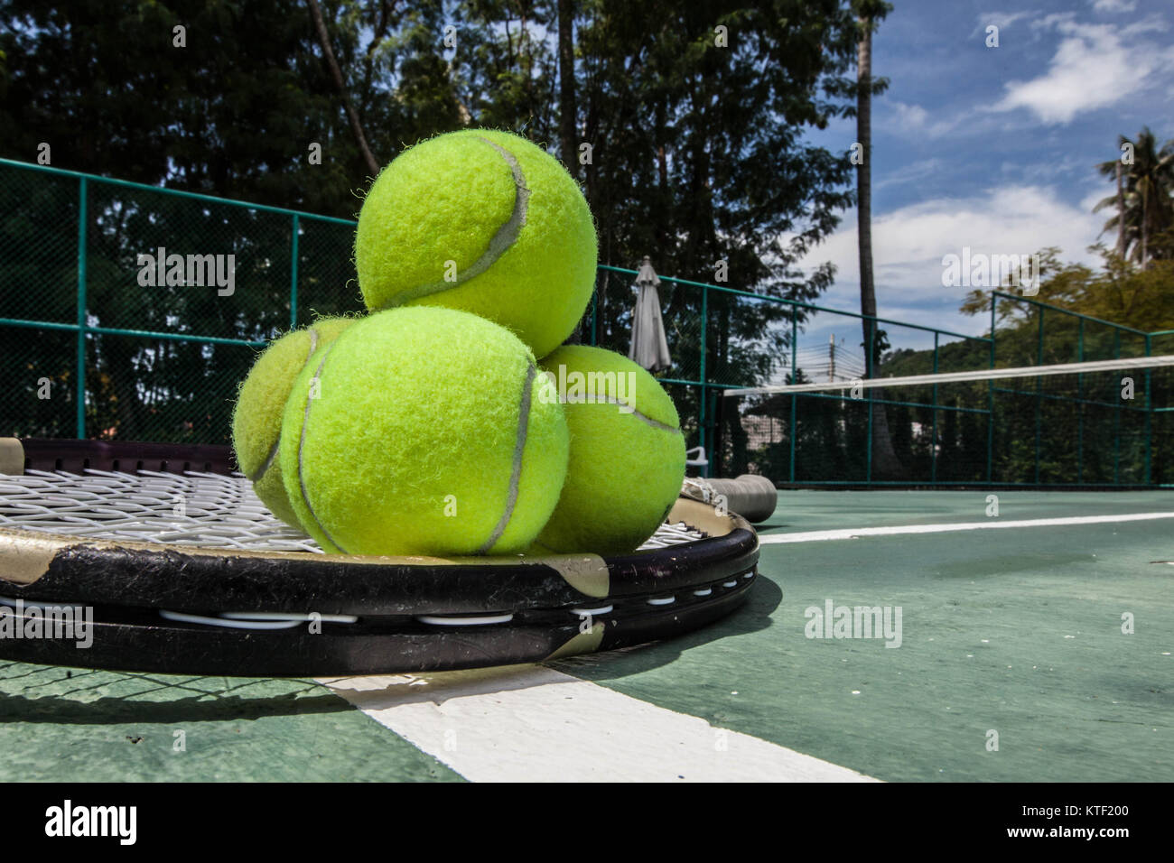 Tennis balls and racket in tennis court outdoors Stock Photo - Alamy