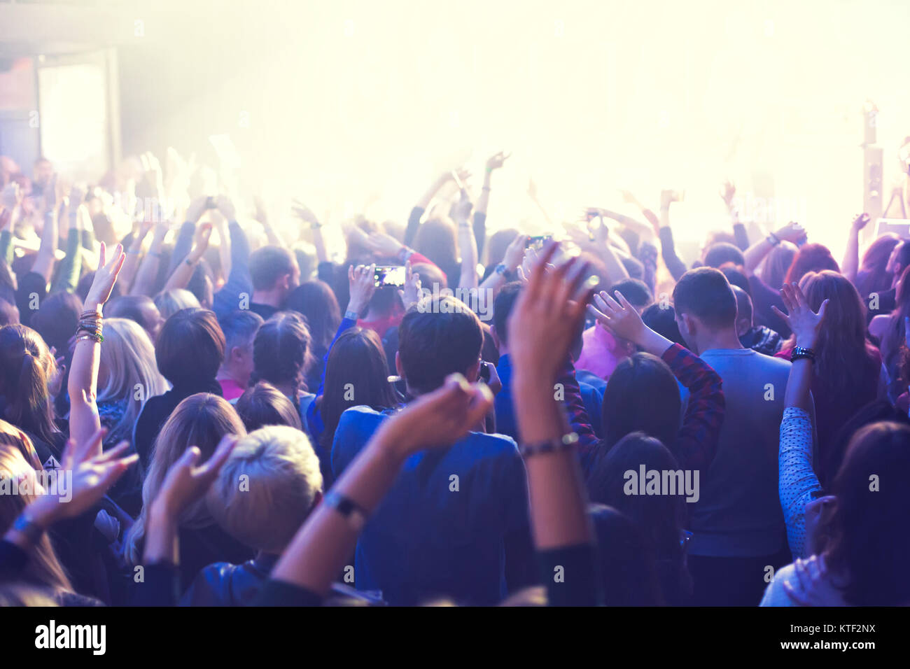 A crowd of spectators at a concert in a small concert club. Applaud and ...