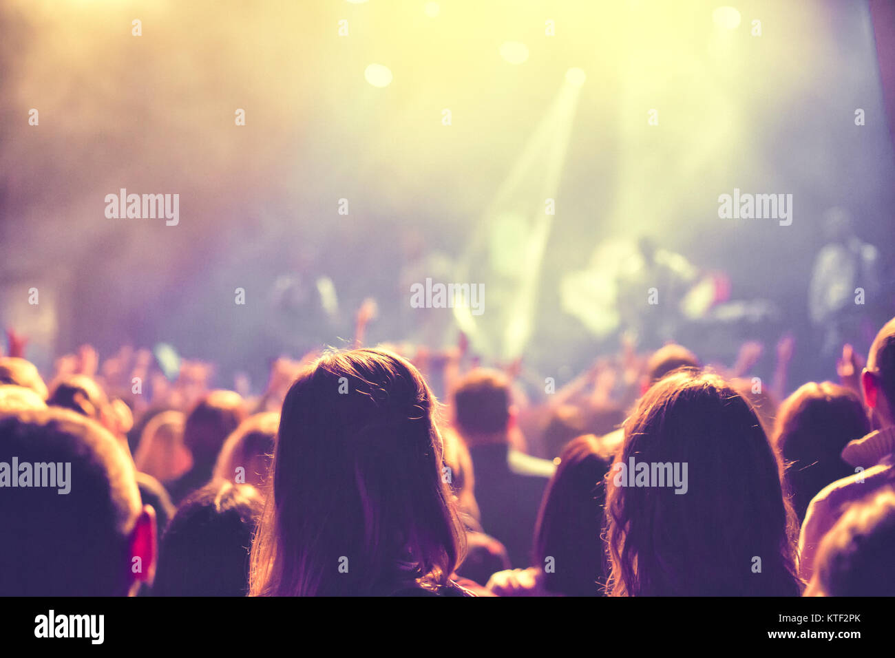 A crowd of spectators at a concert in a small concert club. Applaud and ...