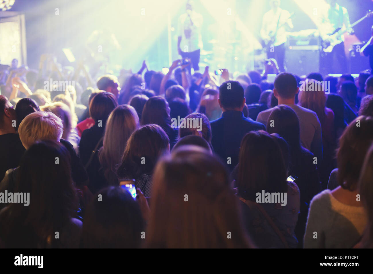 A crowd of spectators at a concert in a small concert club. Applaud and ...