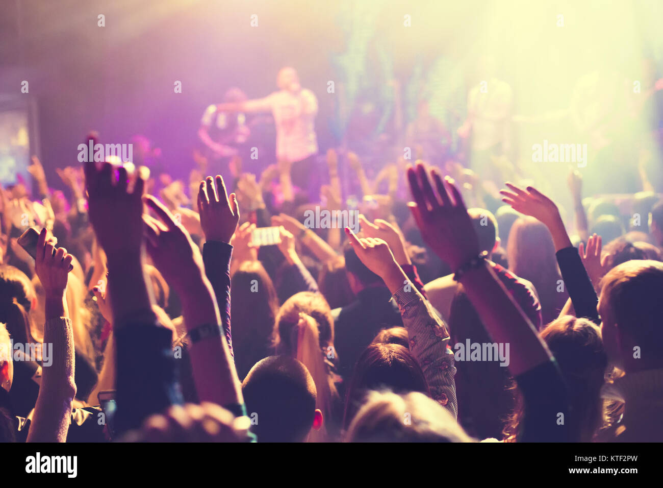 A crowd of spectators at a concert in a small concert club. Applaud and ...
