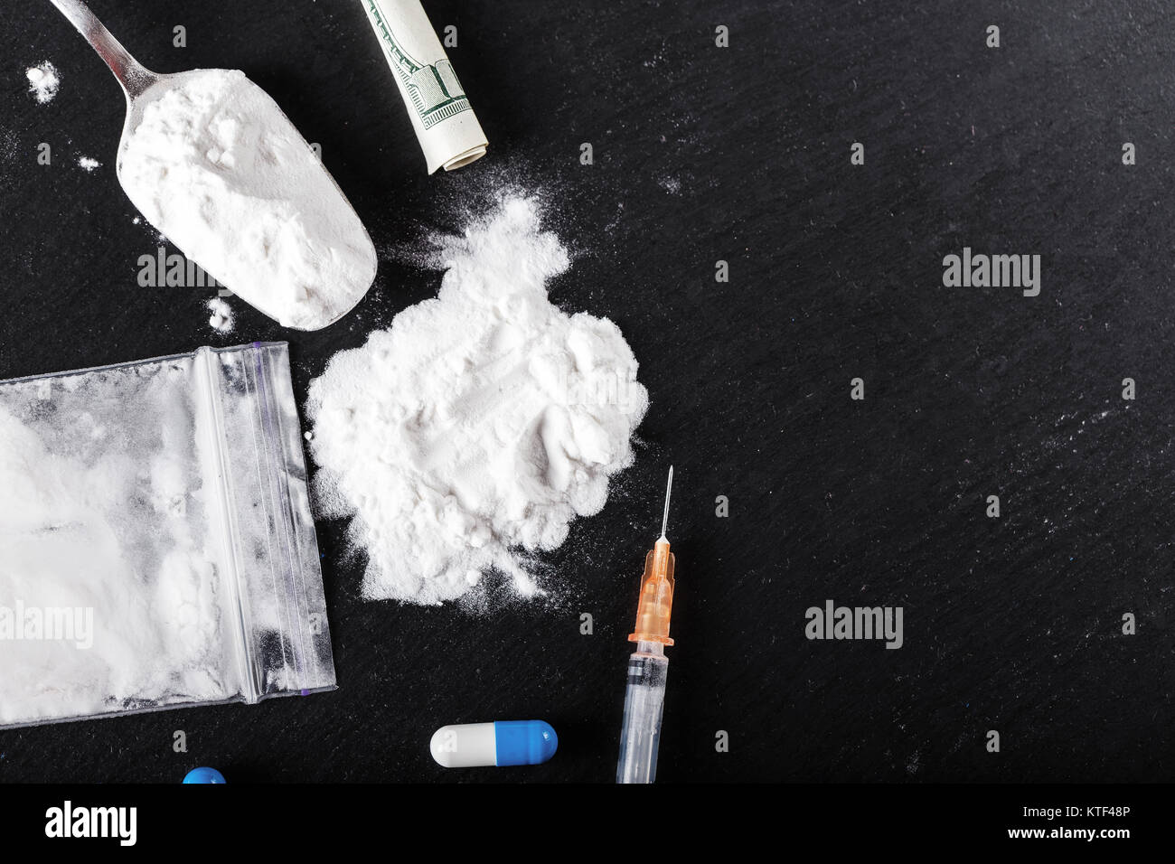 drugs in the form of a white powder on a black background, next is a ...