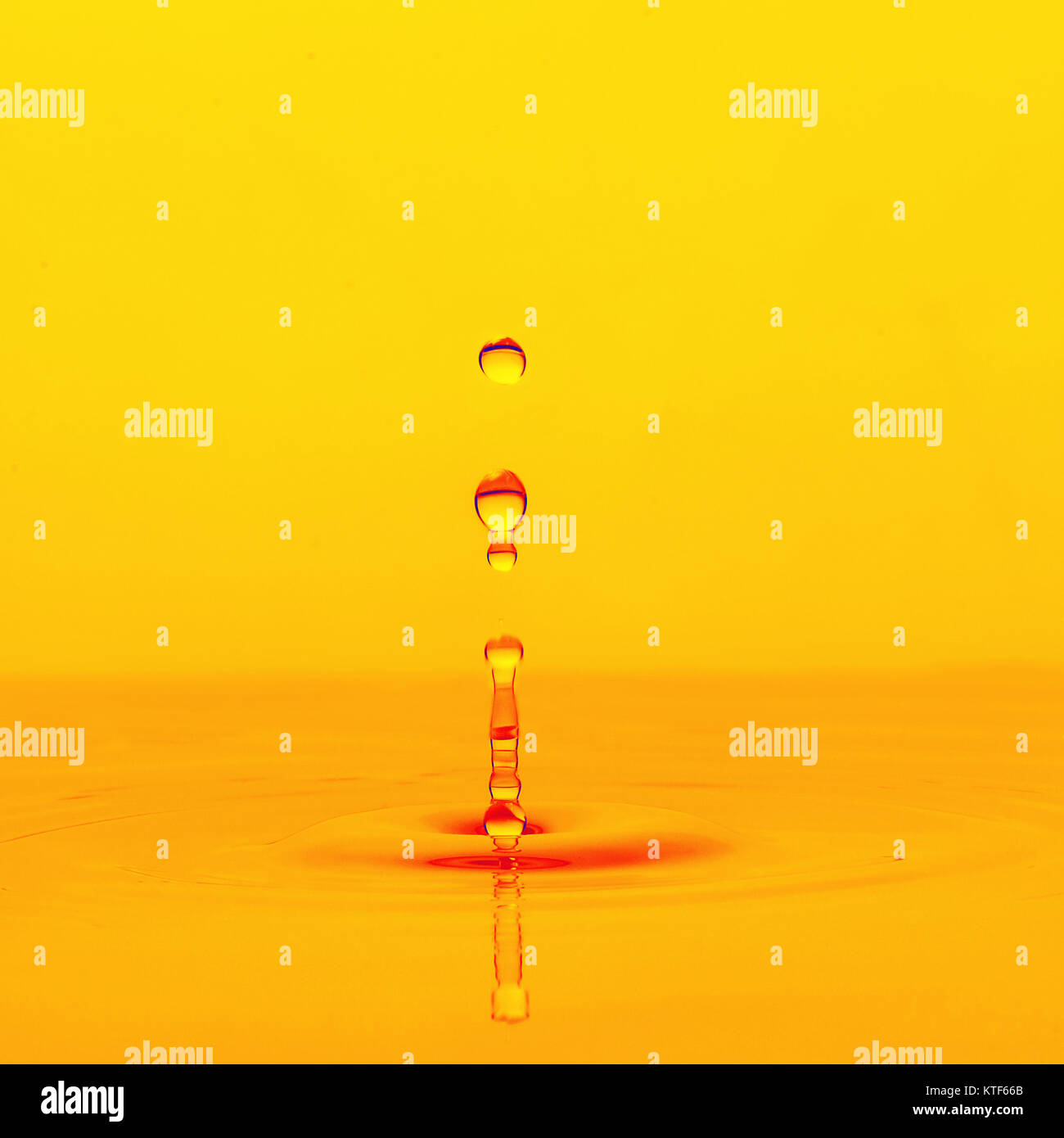 yellow water drop falling down Stock Photo - Alamy