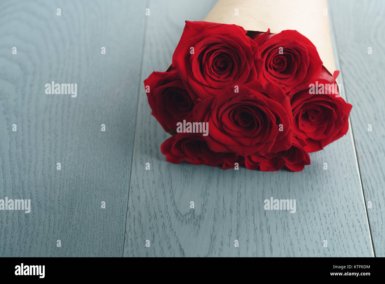 seven red roses rustic paper bouquet on blue wood table Stock Photo - Alamy