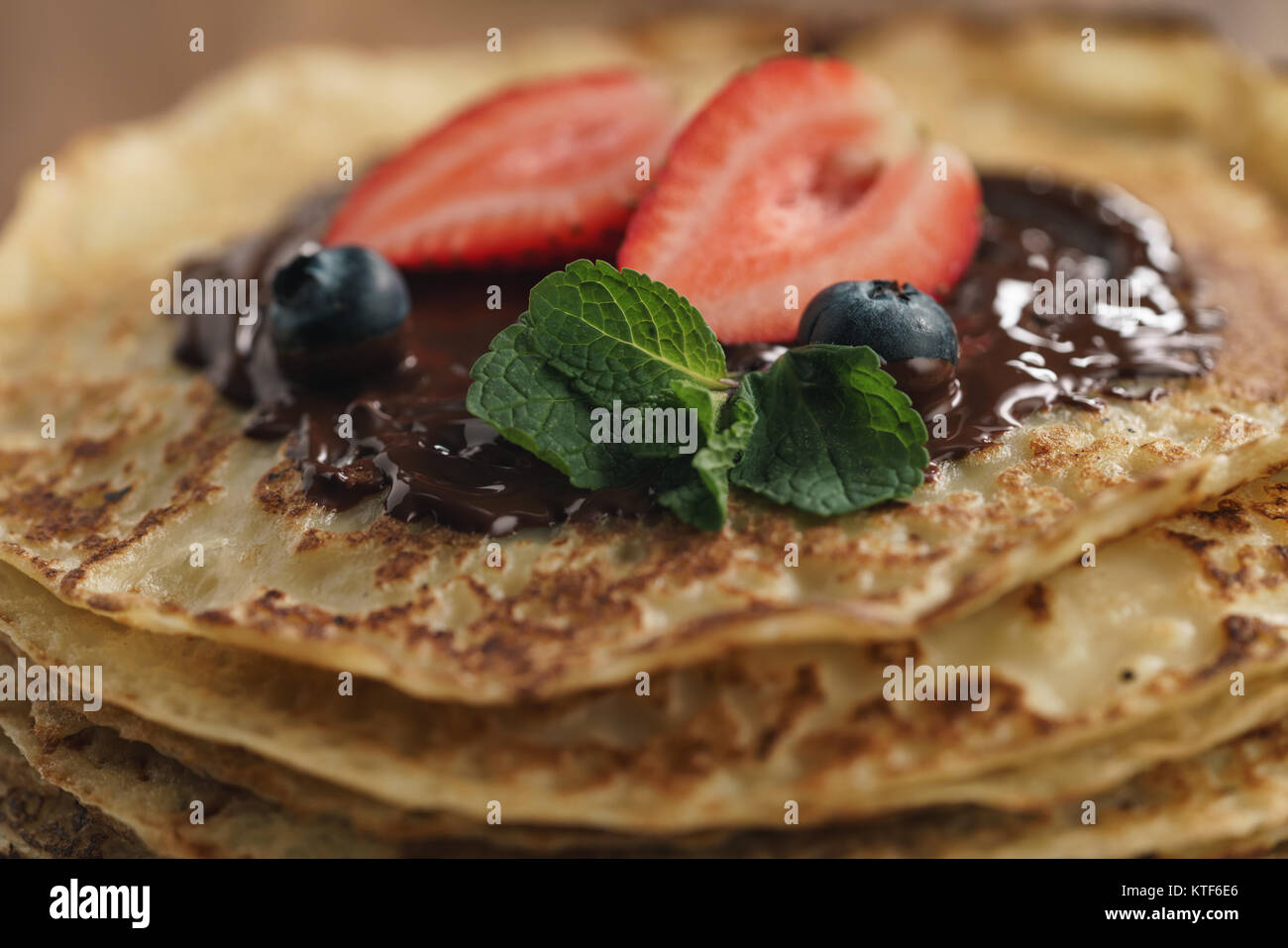 stack of crepes with berries and dark chocolate poured on top Stock ...