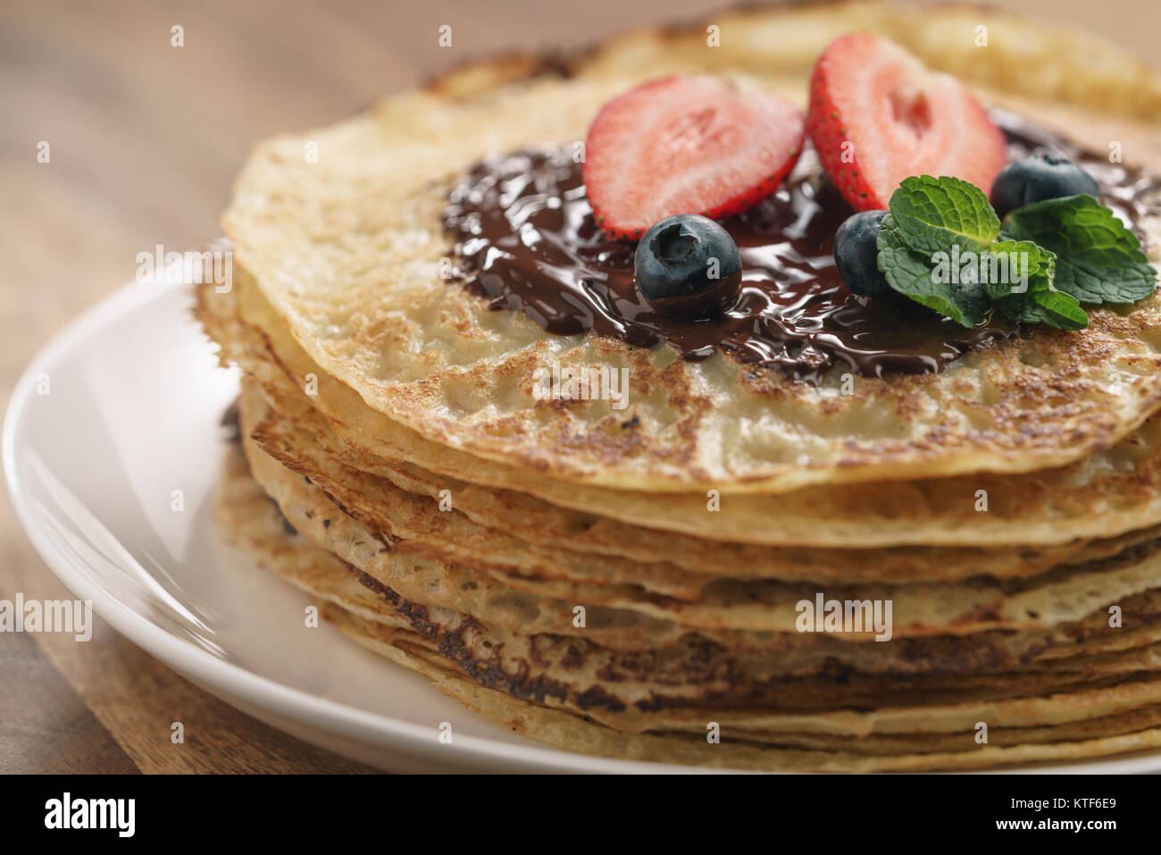 stack of crepes with berries and dark chocolate poured on top Stock ...