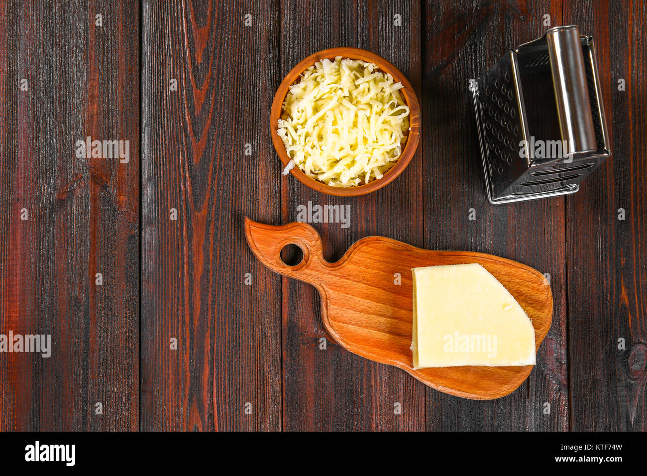 Portion of grated Cheddar Cheese on rustic wooden table Stock Photo - Alamy