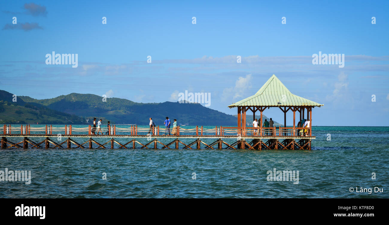 Mahebourg, Mauritius - Jan 3, 2017. People walk on the bridge at jetty ...