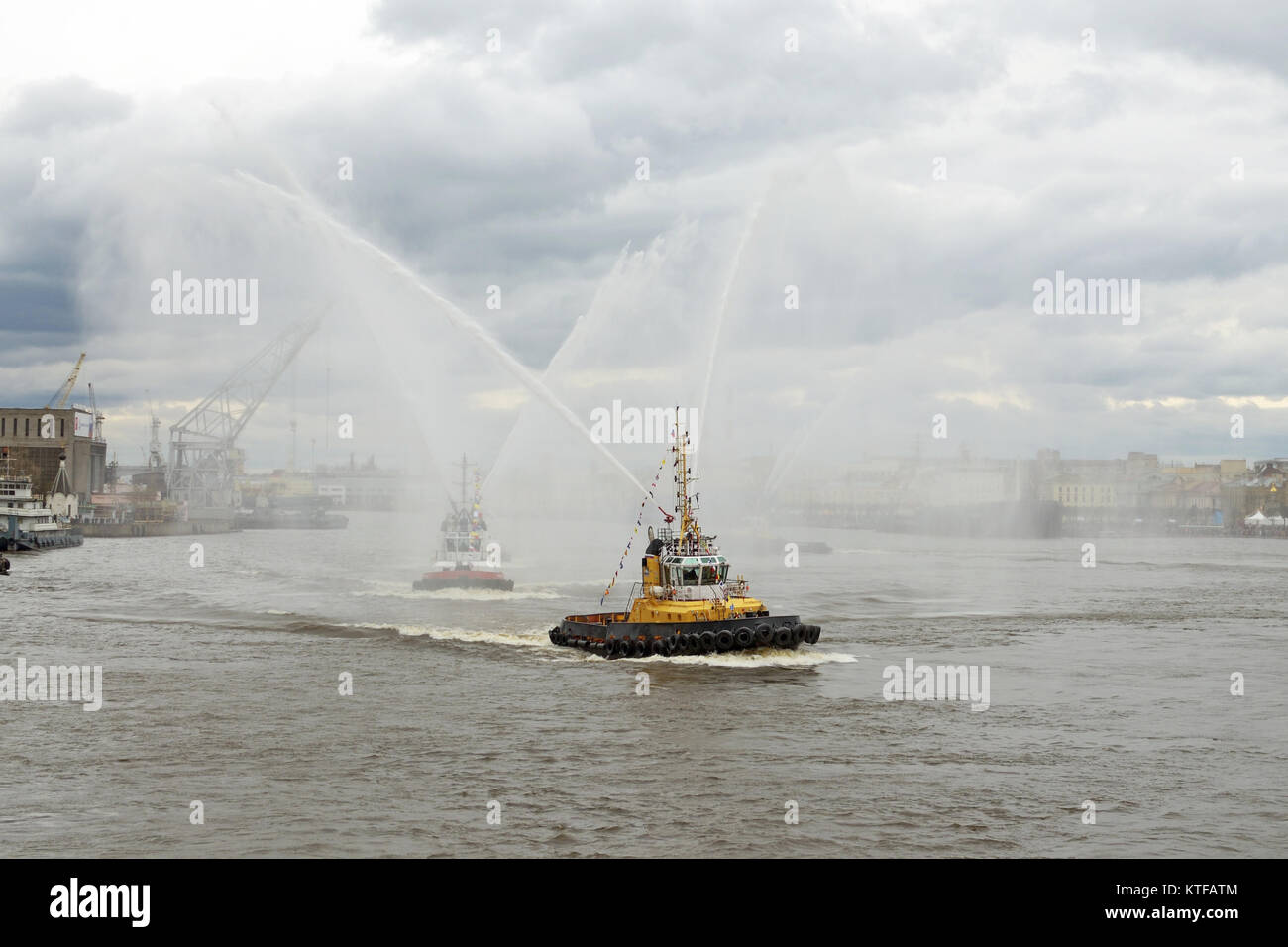 Marine boat tug boat floats on the river and throws up water fountains ...