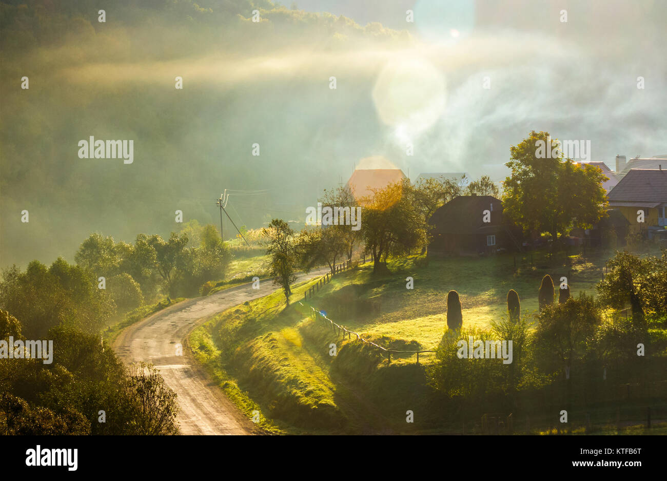 smoke and fog over the village at sunrise. beautiful rural scenery near ...