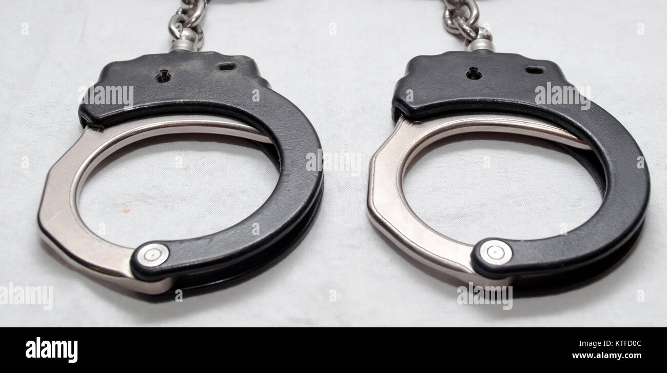 Two single handcuffs on a white background Stock Photo - Alamy