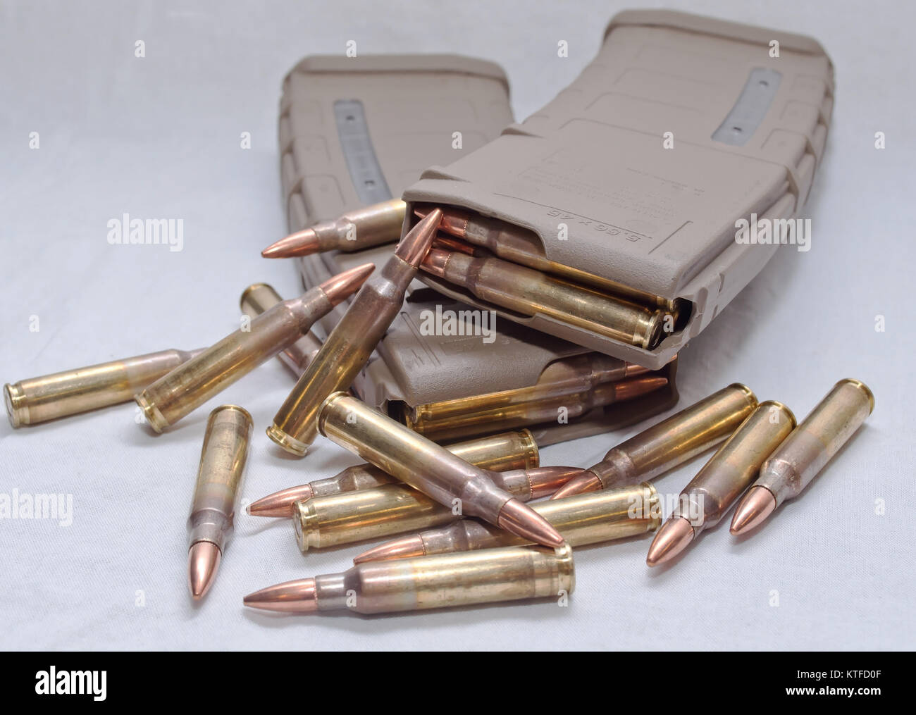 Two brown rifle magazines loaded with .223 rounds and several rounds ...
