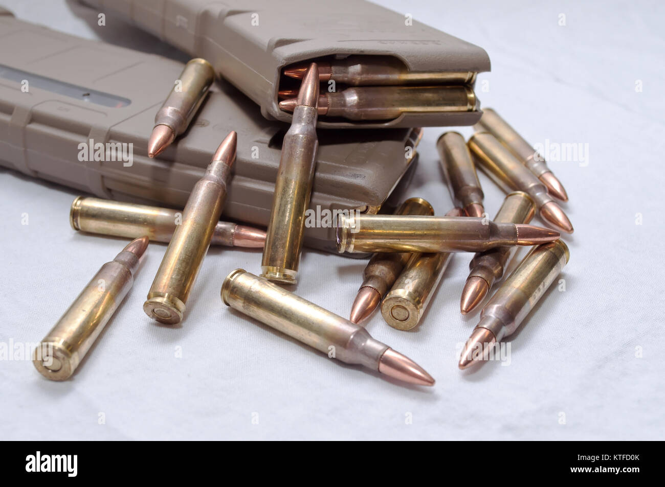 Two brown rifle magazines loaded with .223 rounds and several rounds ...