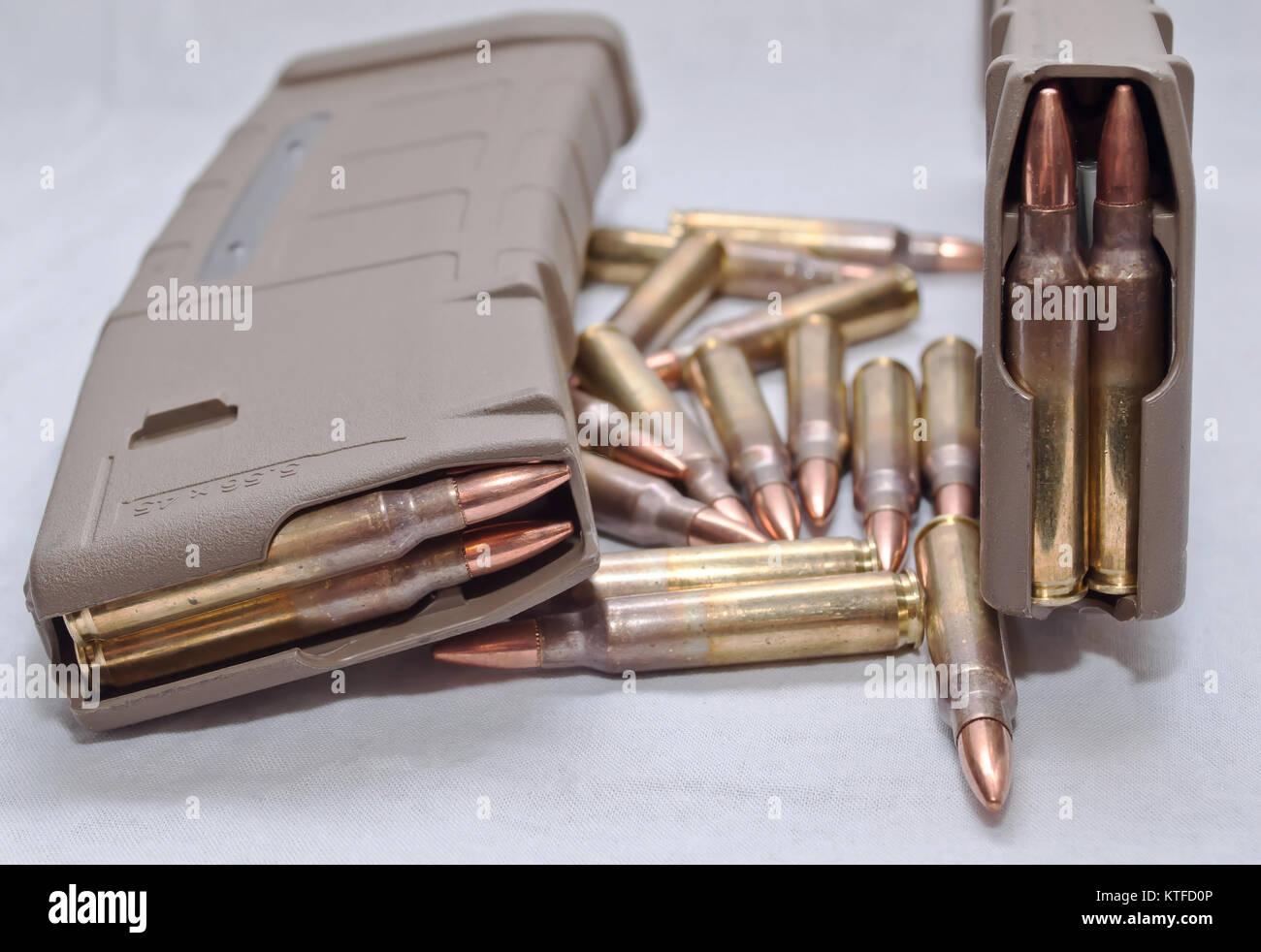 Two brown rifle magazines loaded with .223 rounds and several rounds ...