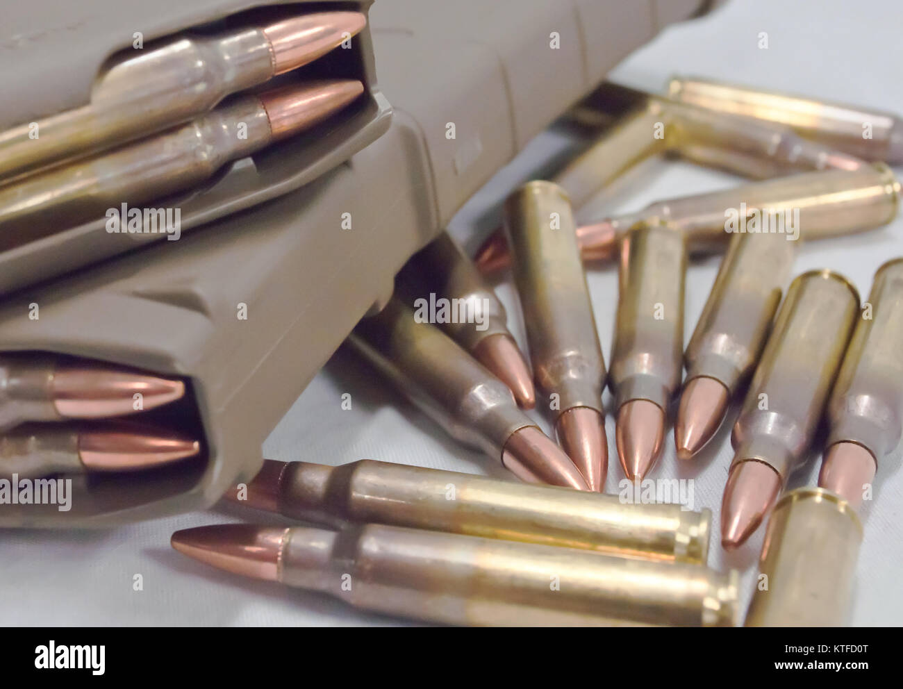 Two brown rifle magazines loaded with .223 rounds and several rounds ...
