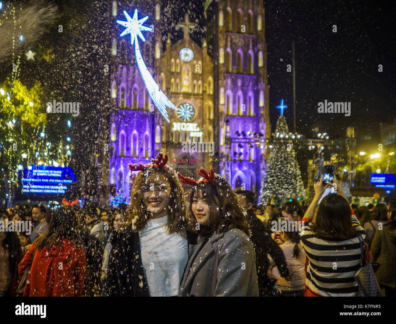 Hanoi, Vietnam. 24th Dec, 2017. Vietnamese women walk through a ...