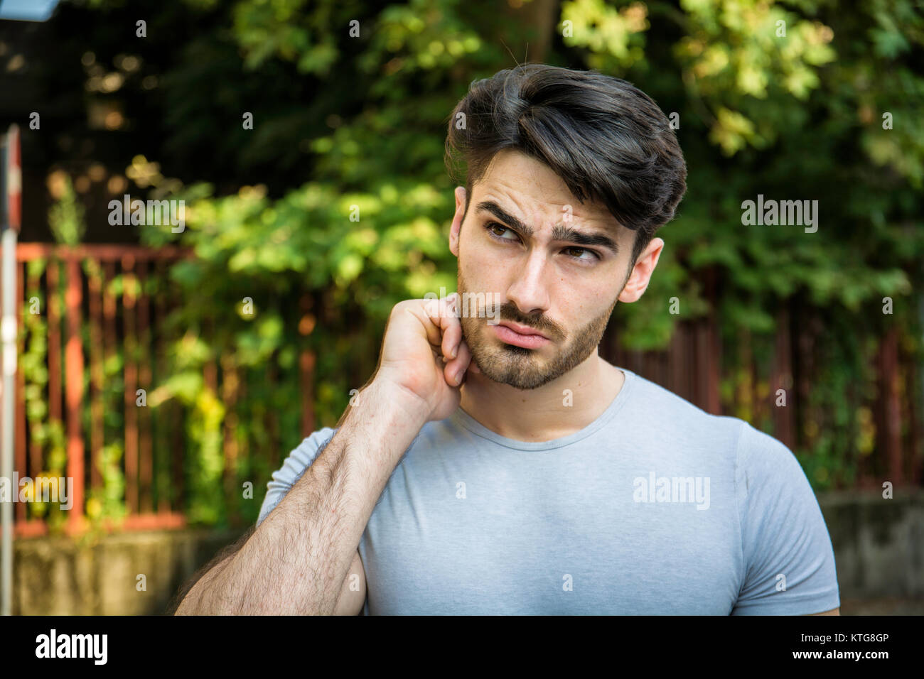 Confused Or Doubtful Young Man Scratching His Head And Looking Up