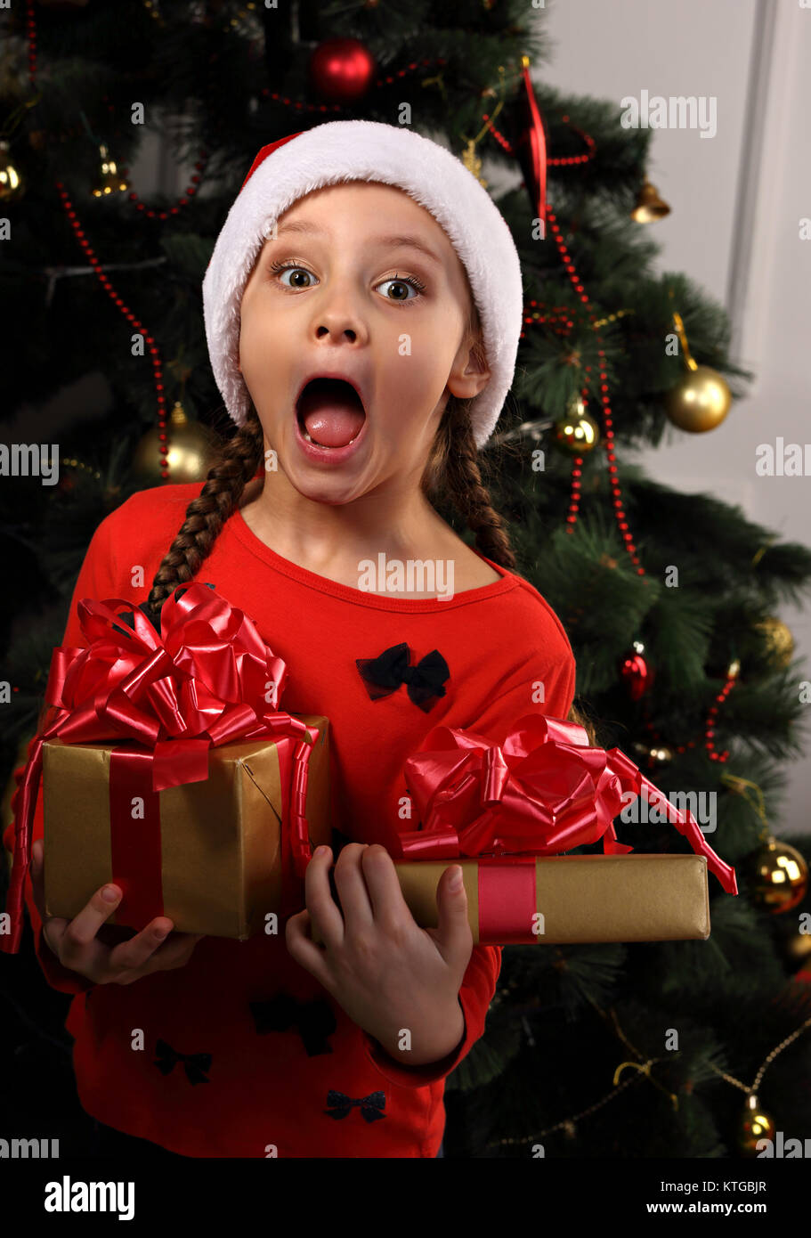 Cute excited surprising kid girl with open mouth in Christmas santa ...