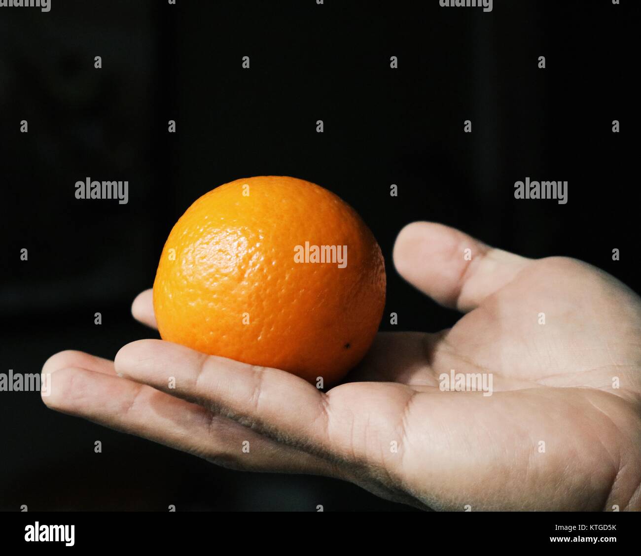 Orange in the hand Stock Photo - Alamy