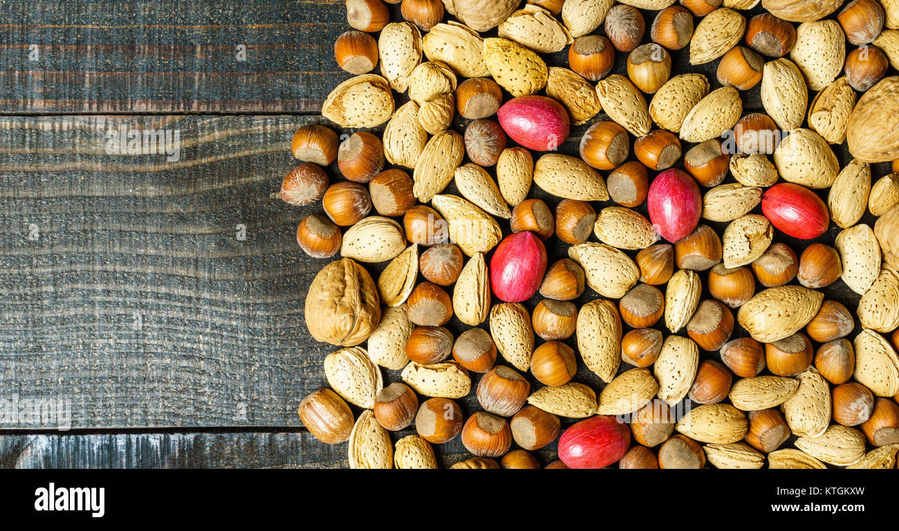 food background with variety of nuts on rustic table Stock Photo - Alamy
