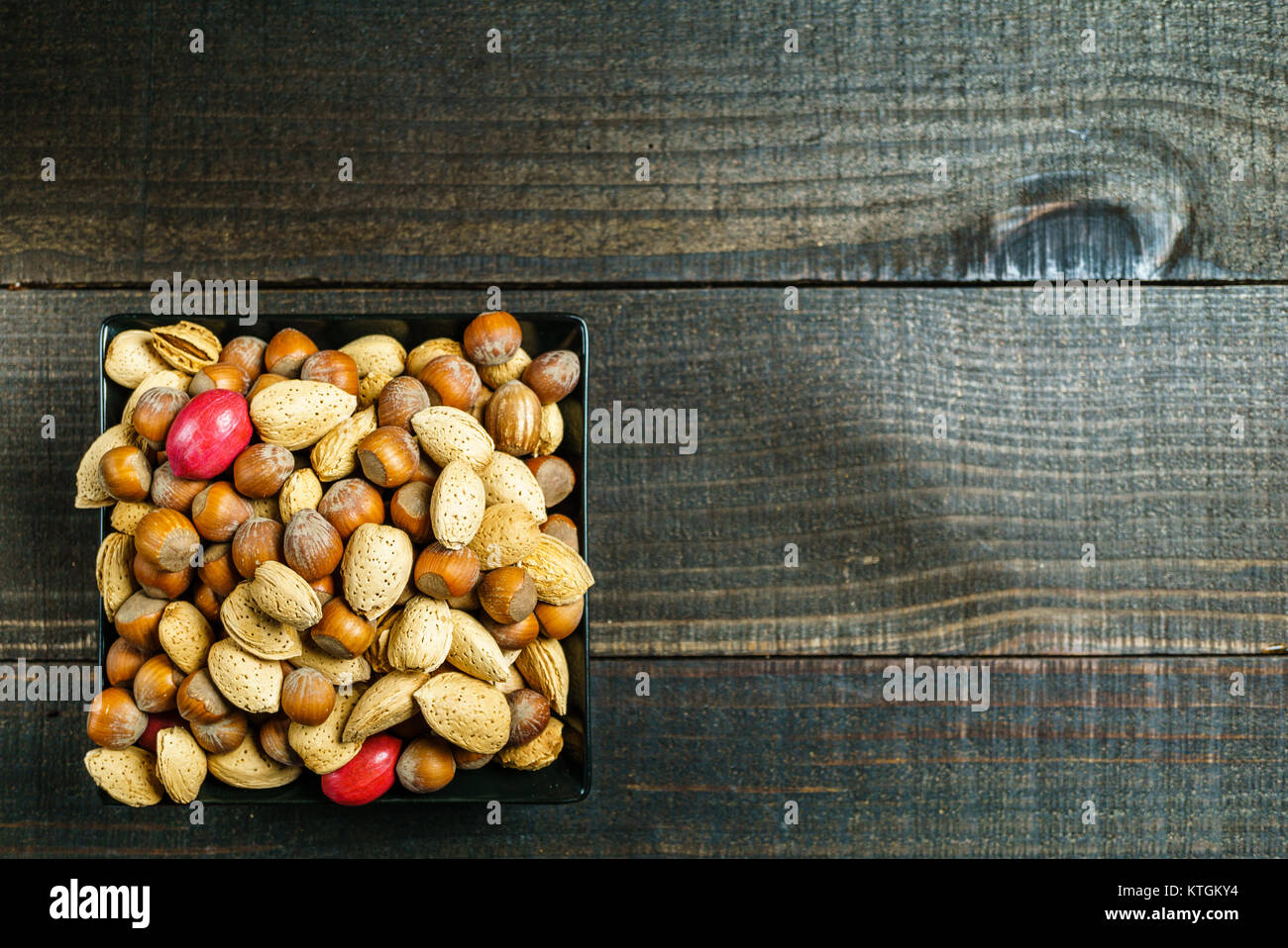 food background with variety of nuts on rustic table Stock Photo - Alamy