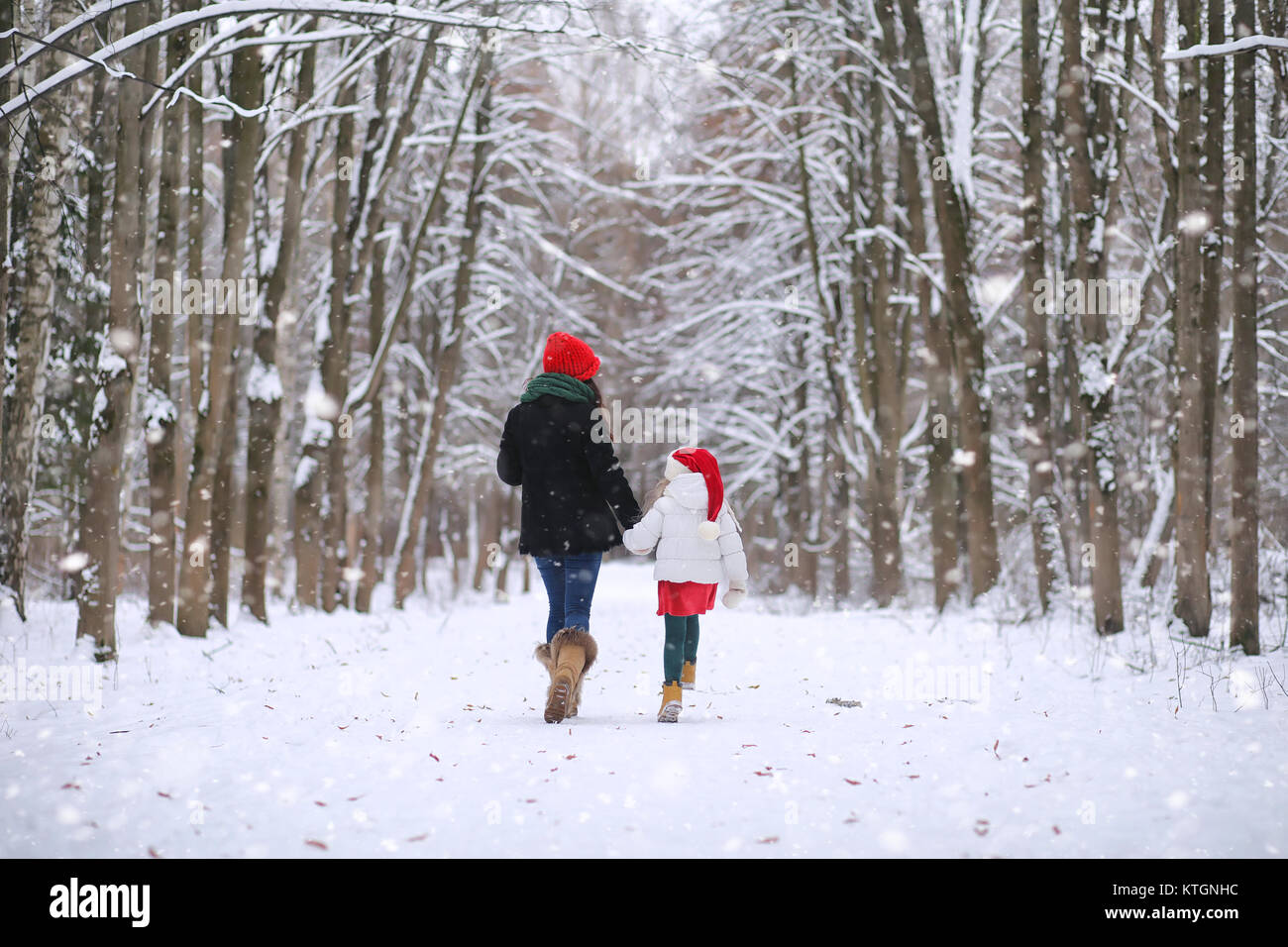 Winter fairy tale, a young mother and her daughter ride a sled in the ...