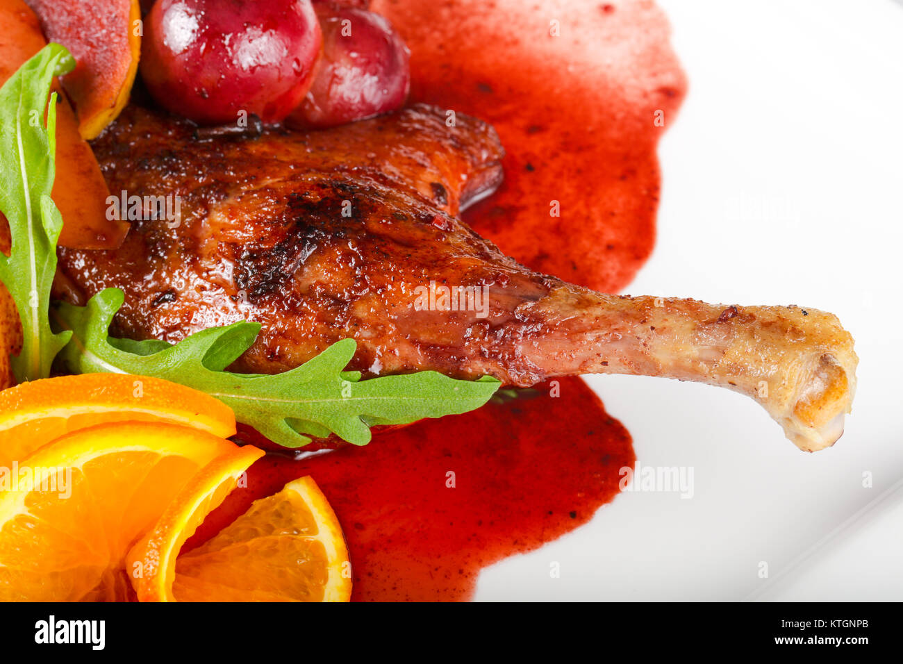 Duck leg with grape, orange and pear Stock Photo - Alamy