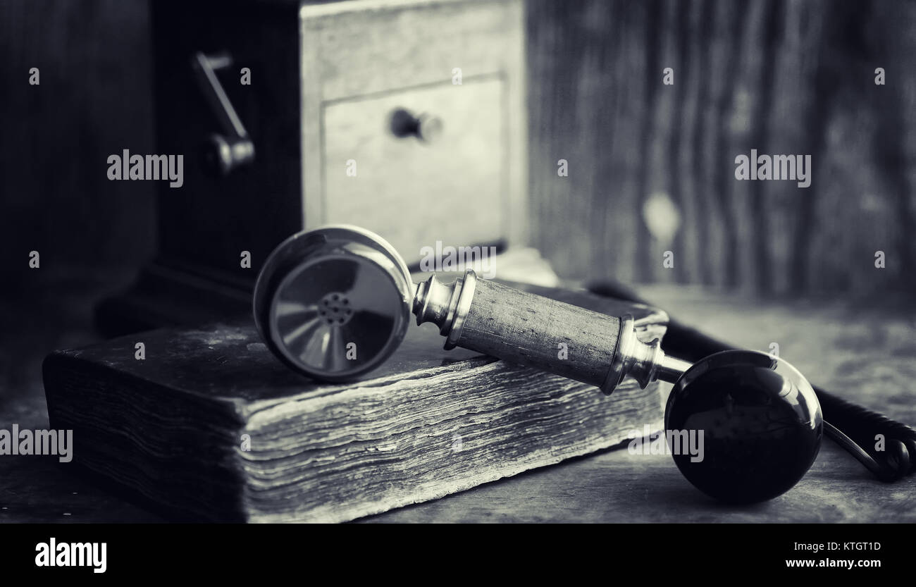 Old telephone and retro book on the desk. The phone of the past on an ...