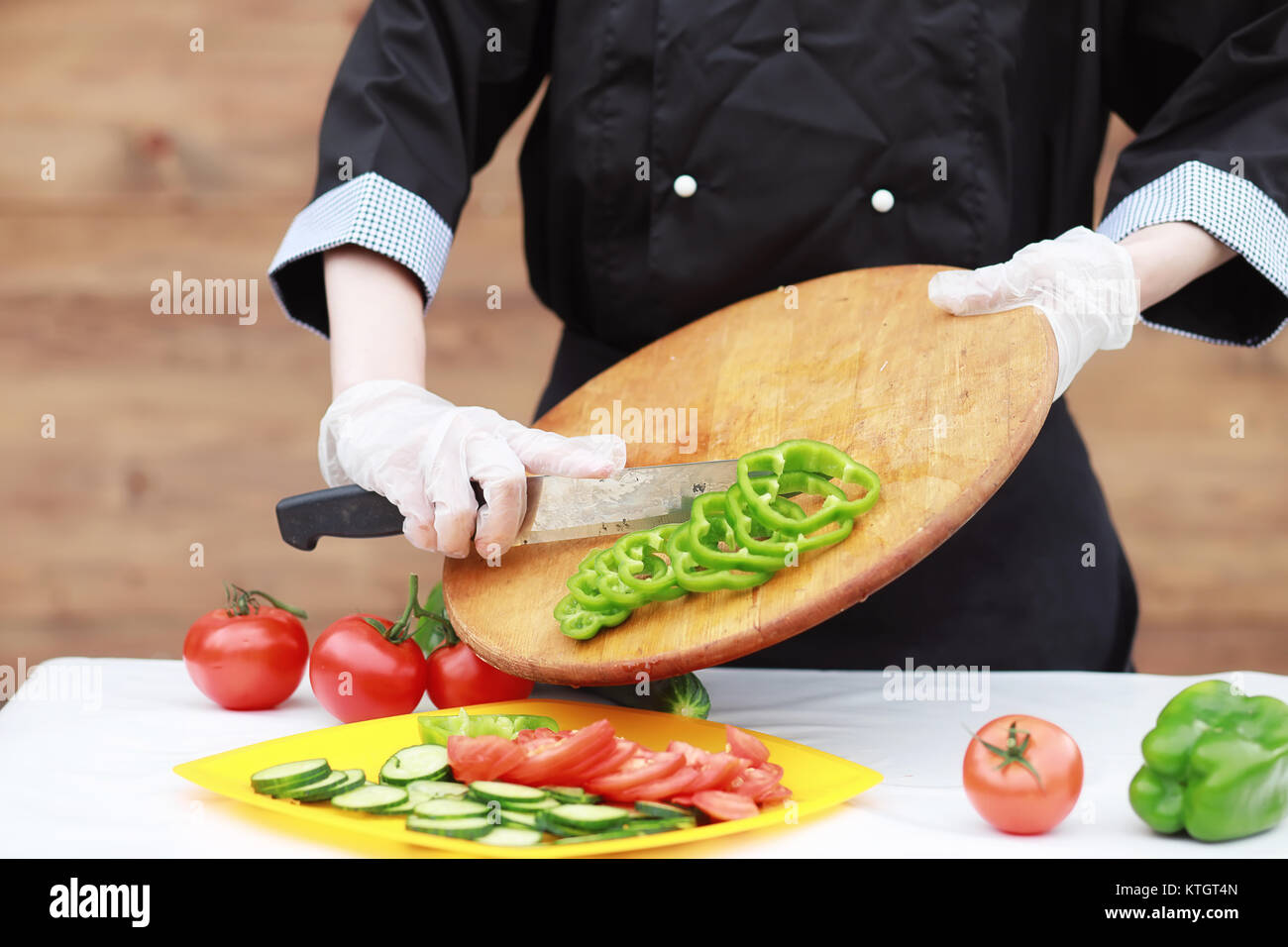 The cook cuts fresh farm vegetables for dinner on the table Stock Photo ...