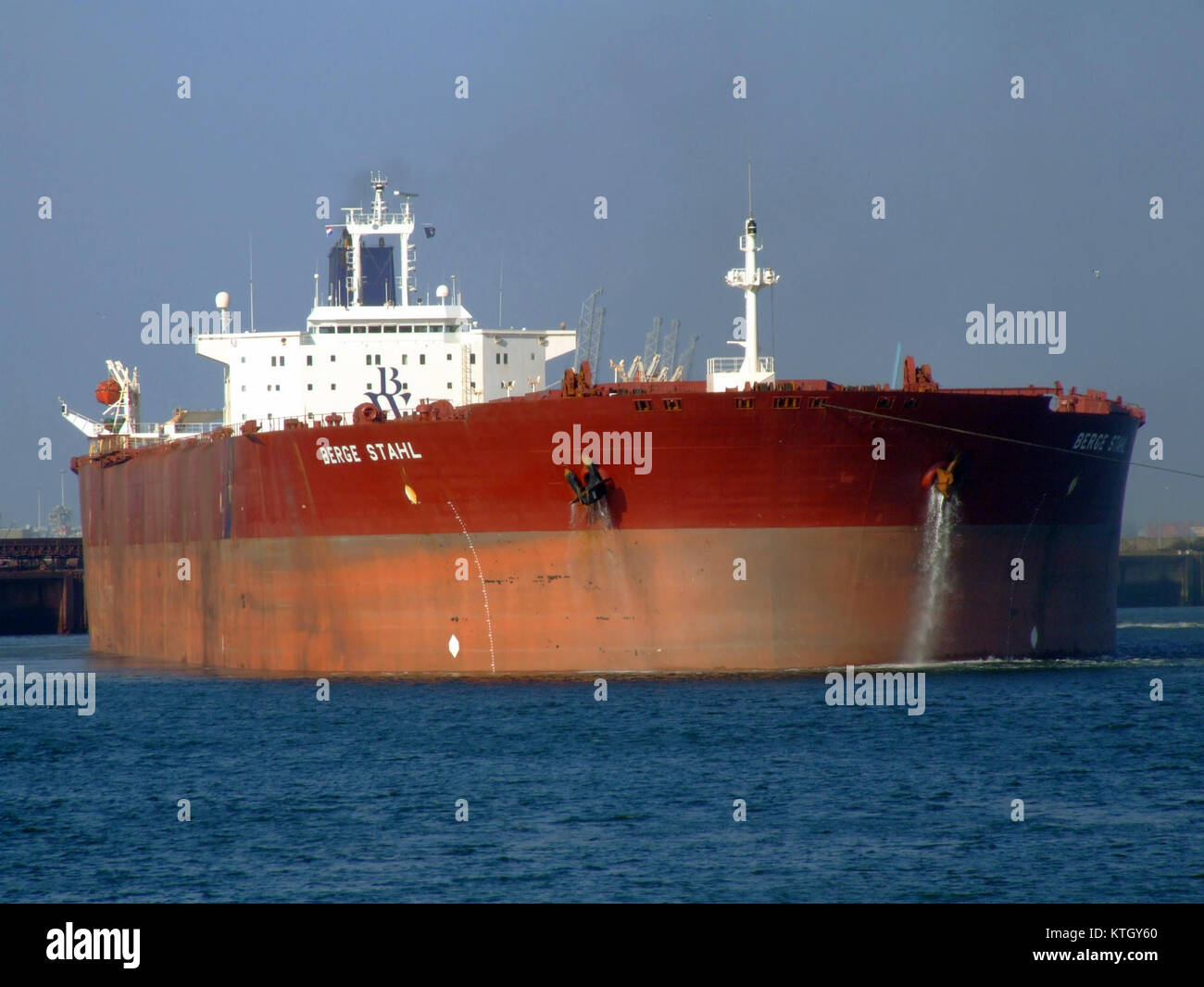 The image shows the Berge Stahl, a bulk carrier ship, docked at the ...