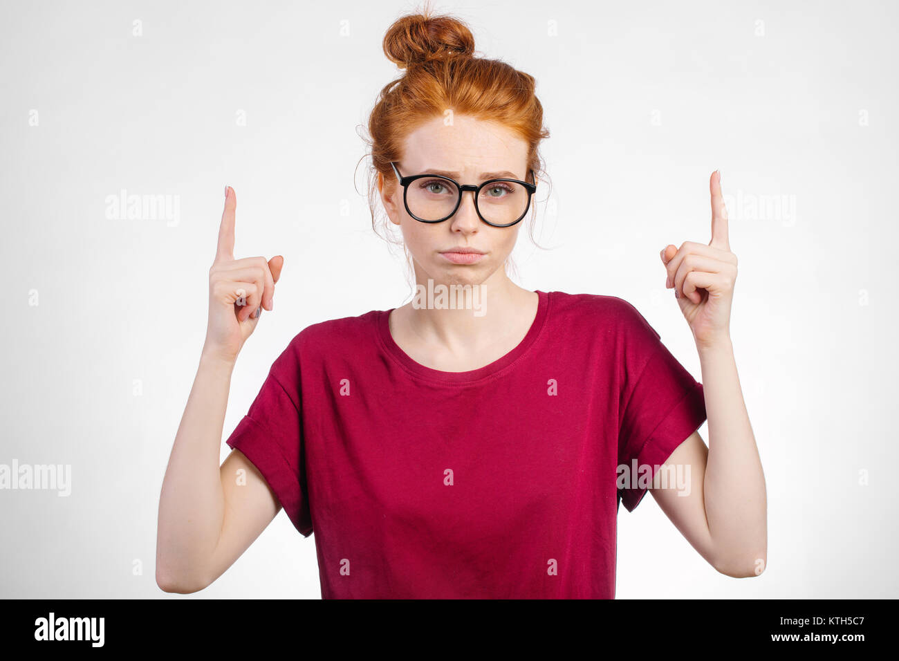 woman pointing up and looking camera. student gesturing her finger ...