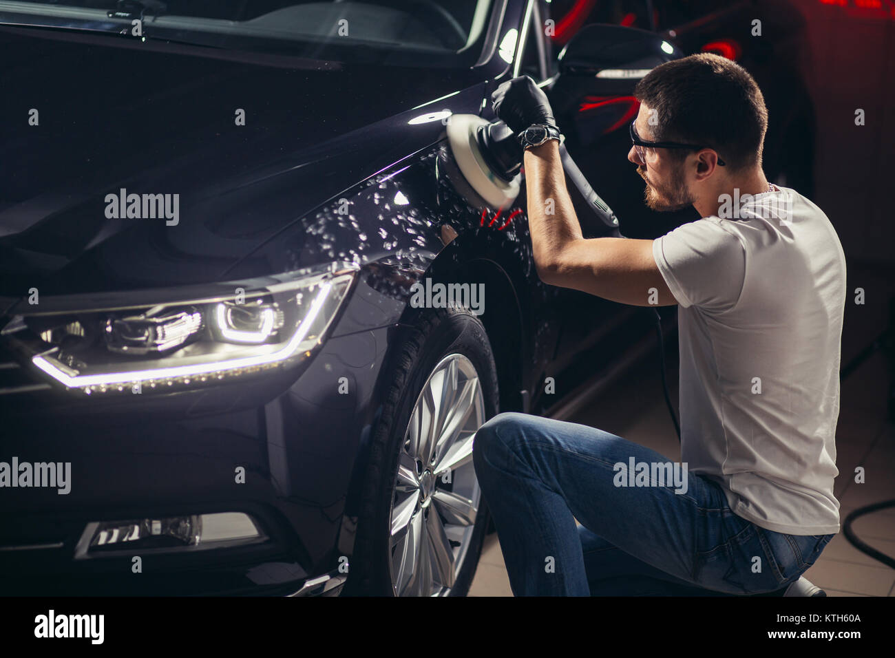 Car detailing - man with orbital polisher in auto repair shop ...